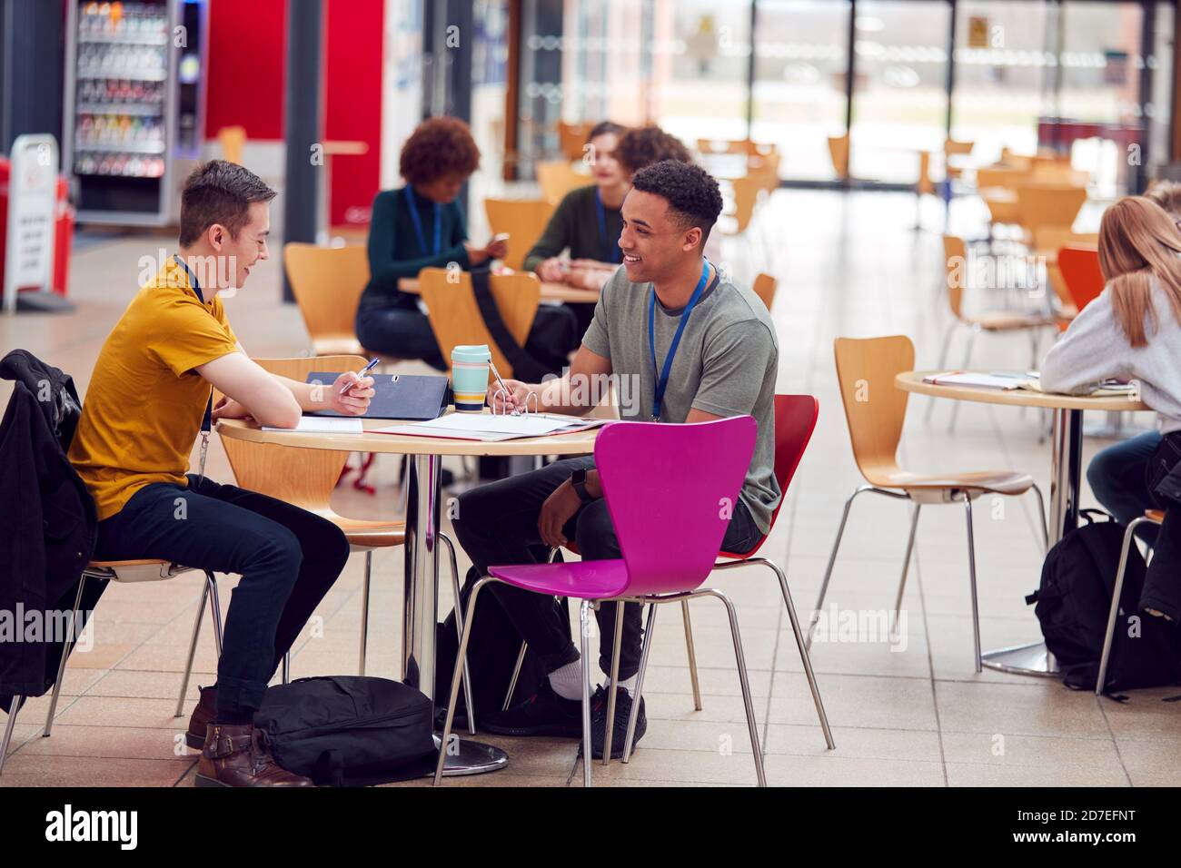 Communal Area Of Busy College Campus With Students Working At Tables ...