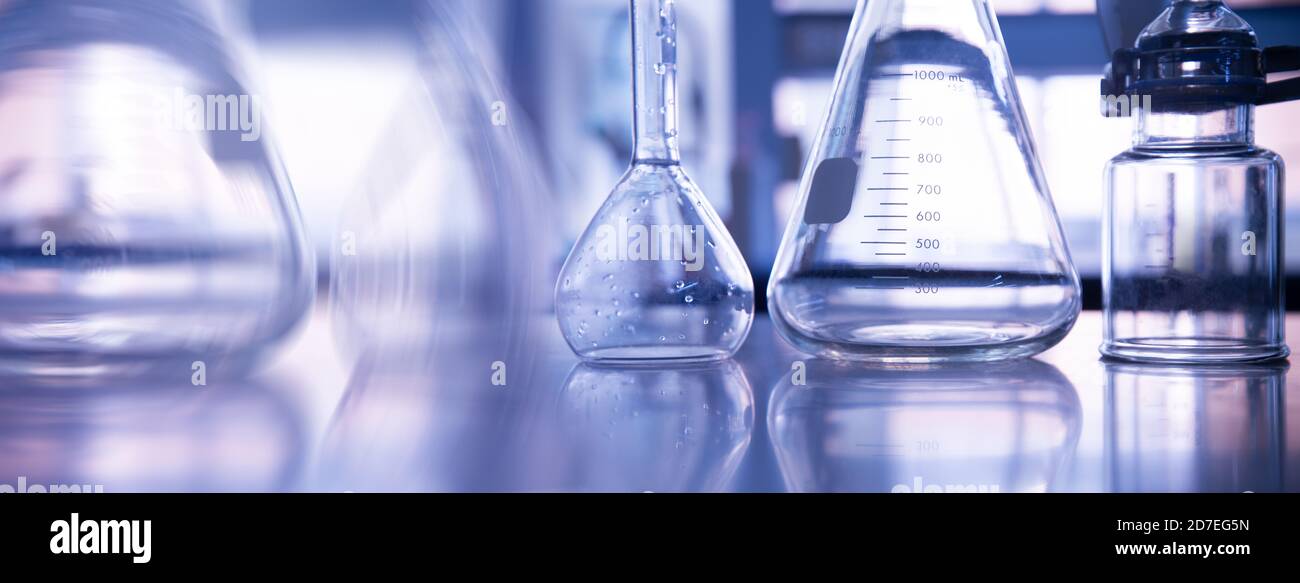 conical and volumetric glass flask with science equipment in chemistry ...