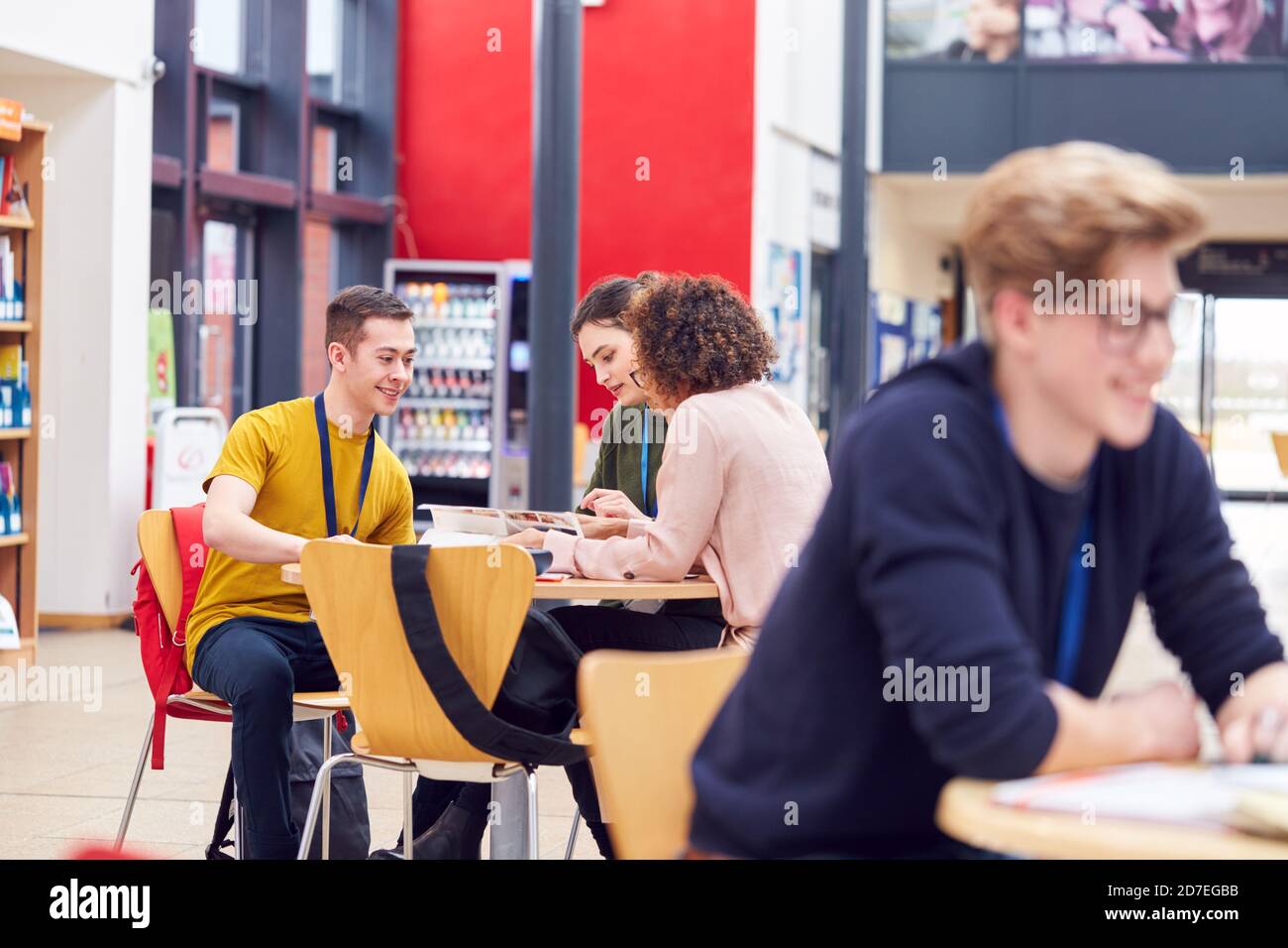 Communal Area Of Busy College Campus With Students Working At Tables ...