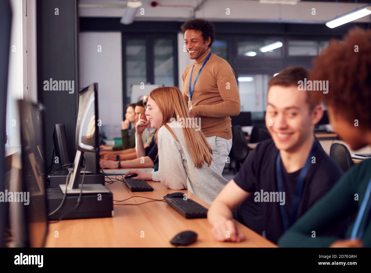 Group Of College Students With Tutor Studying Computer Design Sitting ...