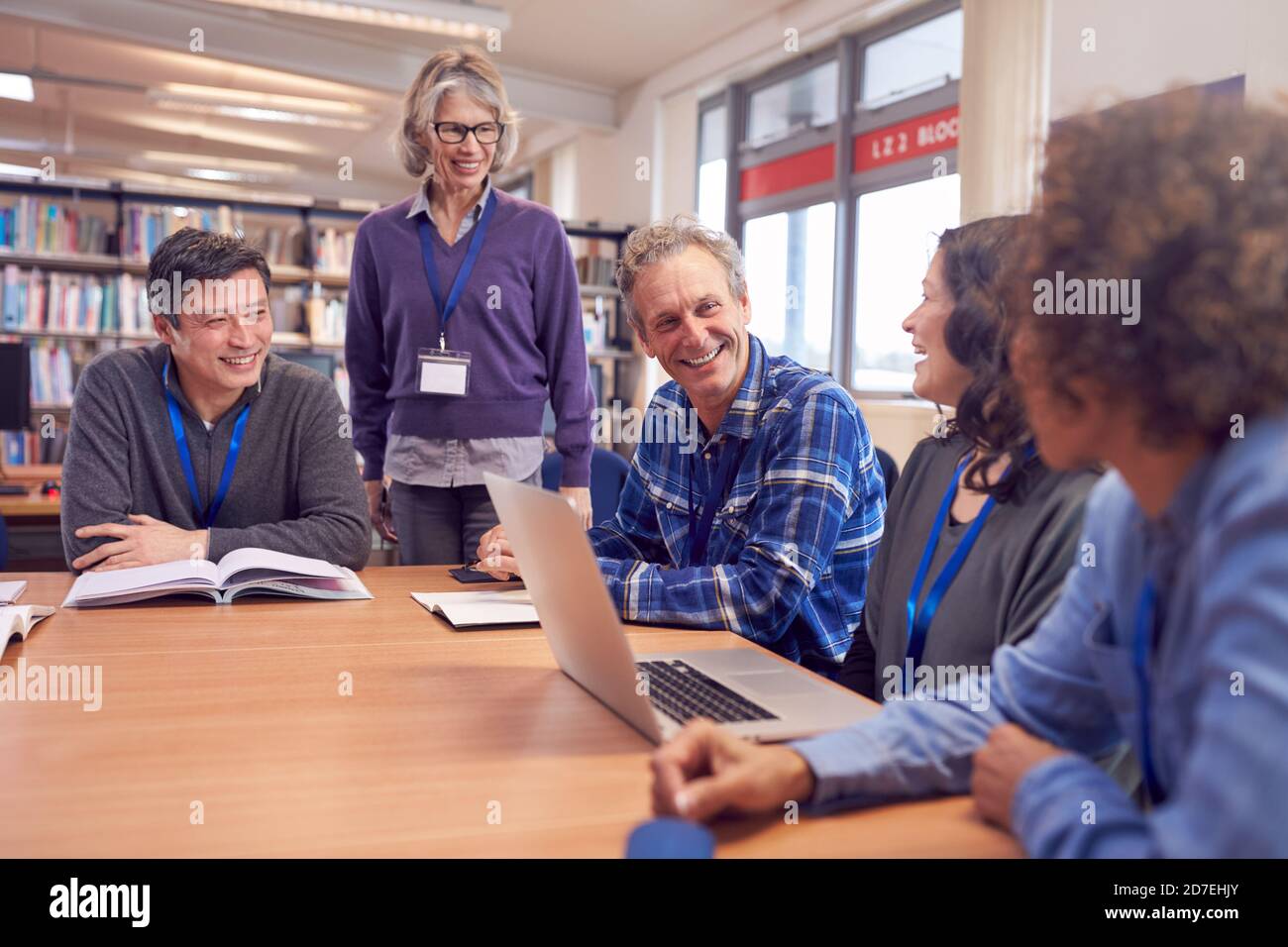 Teacher With Group Of Mature Adult Students In Class Sit Around Table ...