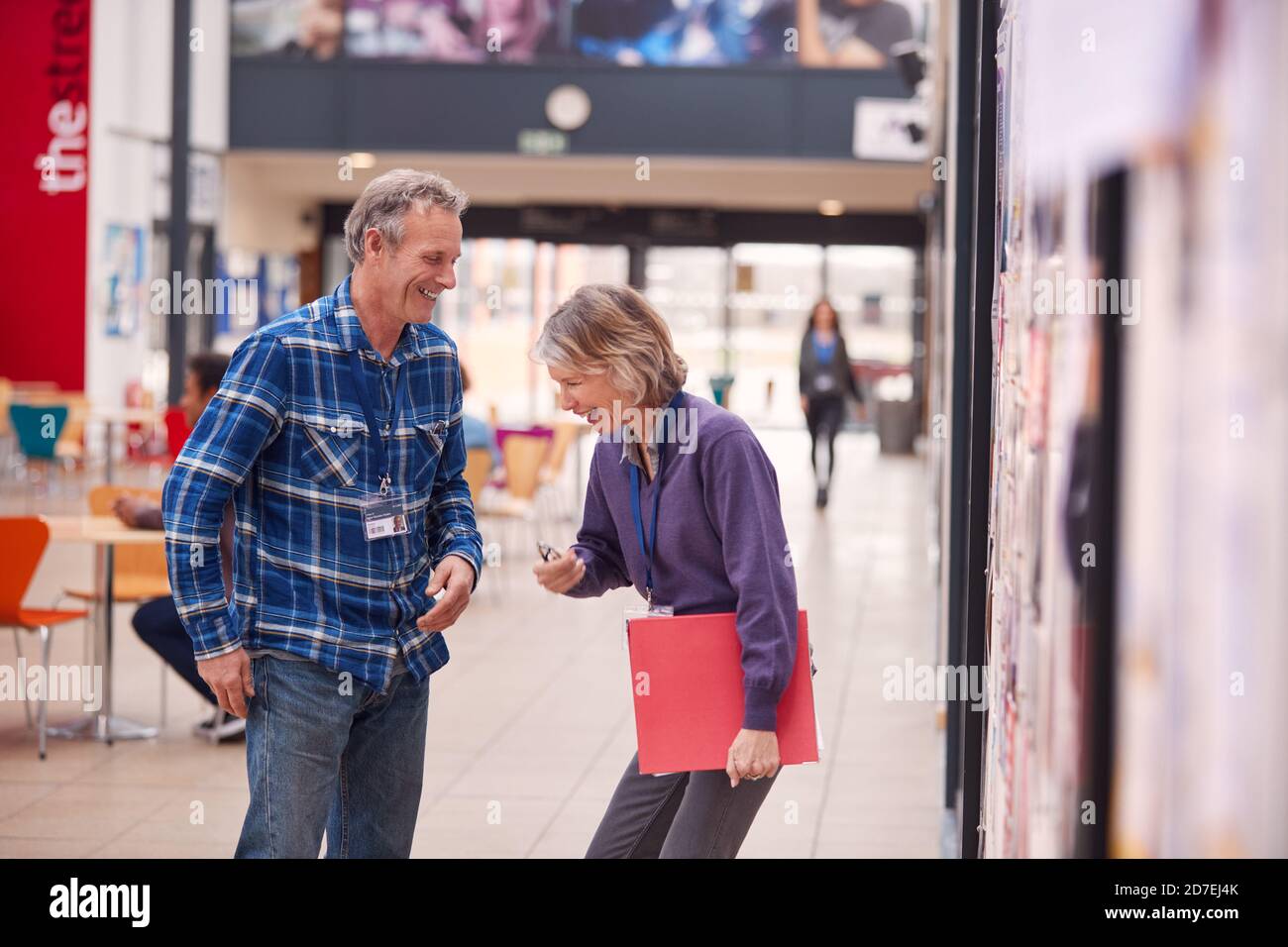 Two Mature Students Or Teachers Walking Through Communal Hall Of Busy ...