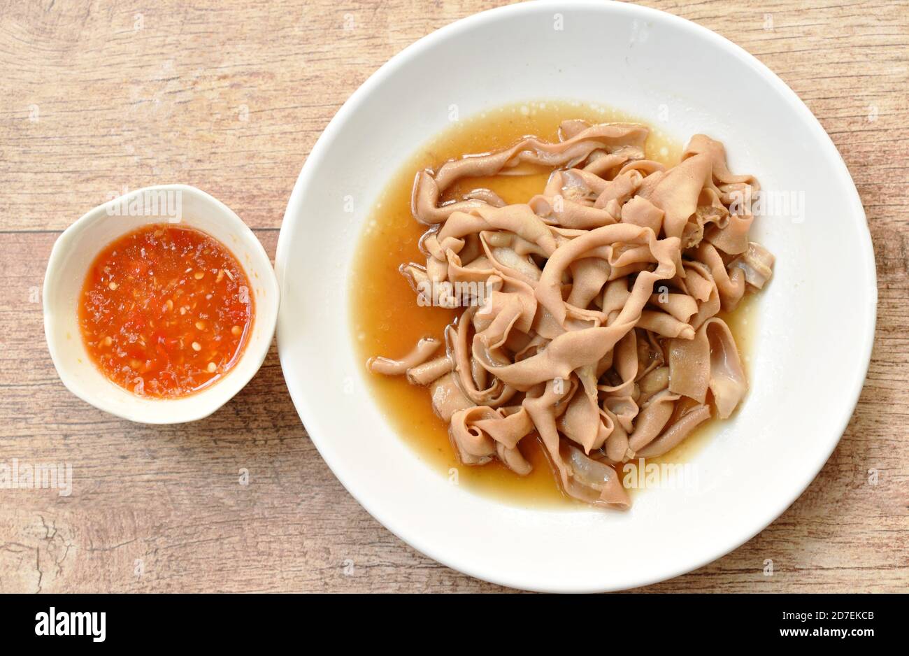 stewed duck intestine in brown soy soup on plate dipping spicy sauce ...