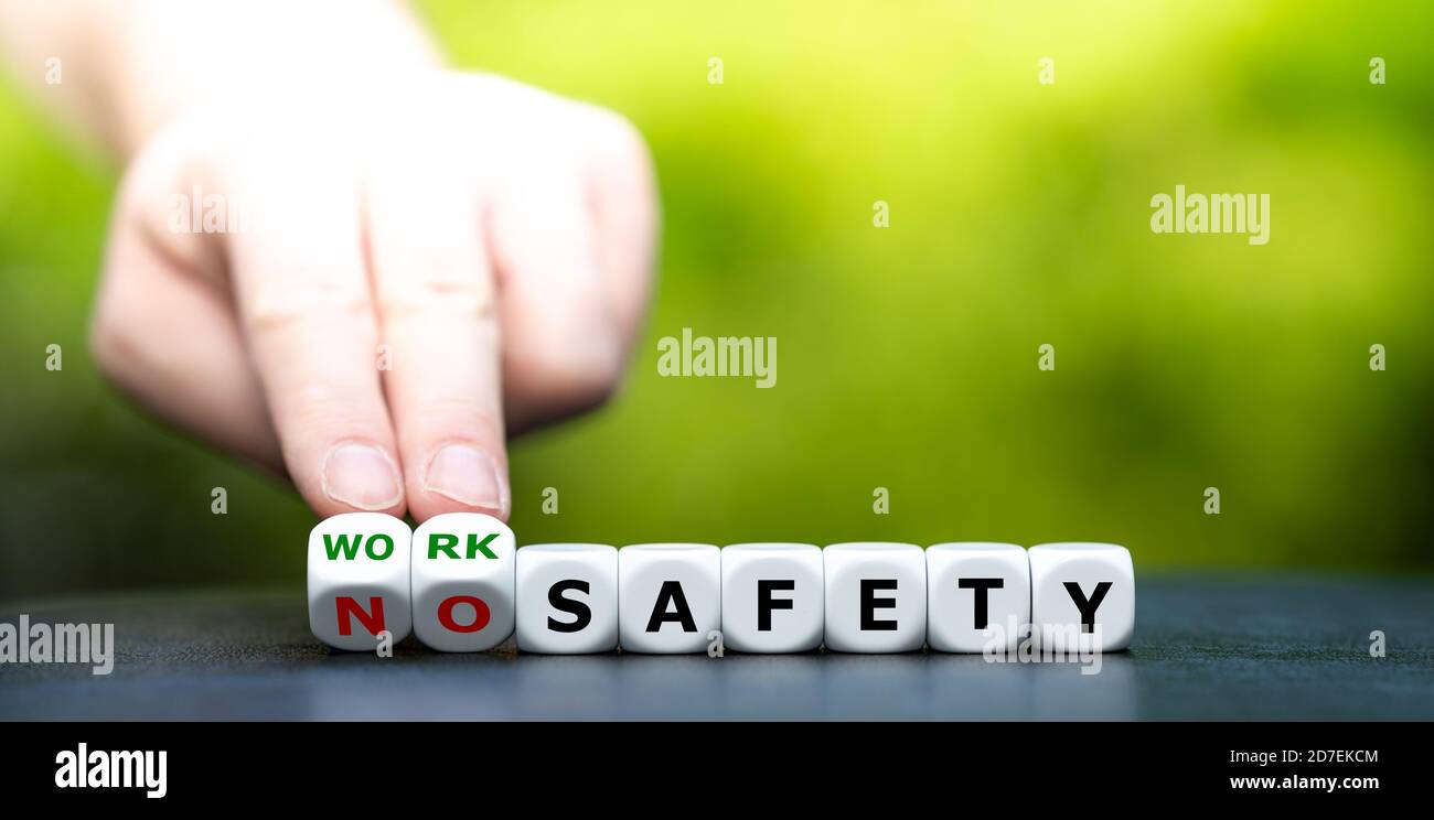 Hand turns dice and changes the expression "no safety" to "work safety ...
