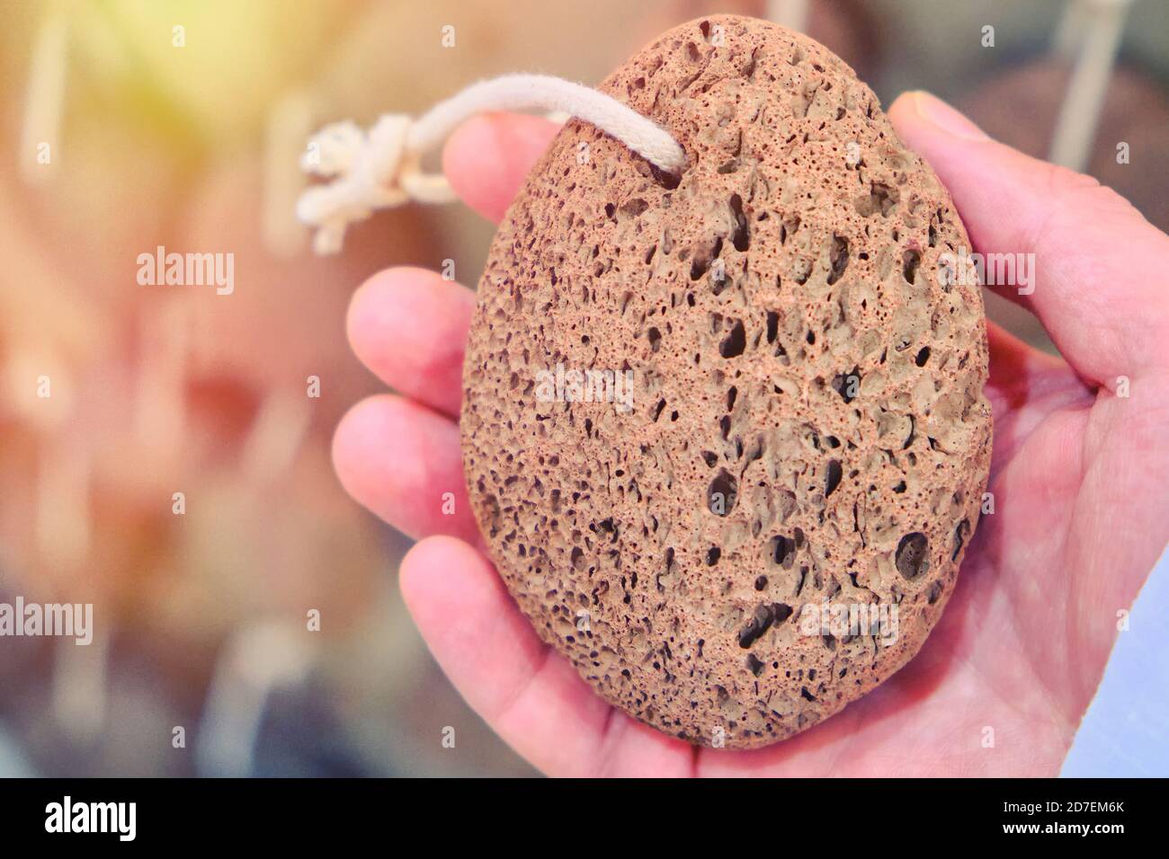 A man holding a pumice stone with a bath rope, close-up. Male hand with ...