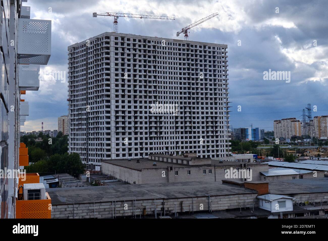 Building a house against a stormy sky. Multi-storey building and tower ...