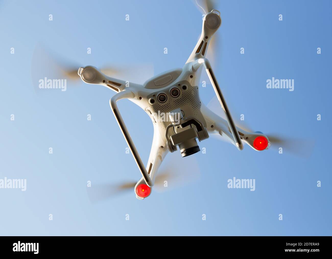 flying quadcopter with camera in blue sky Stock Photo - Alamy