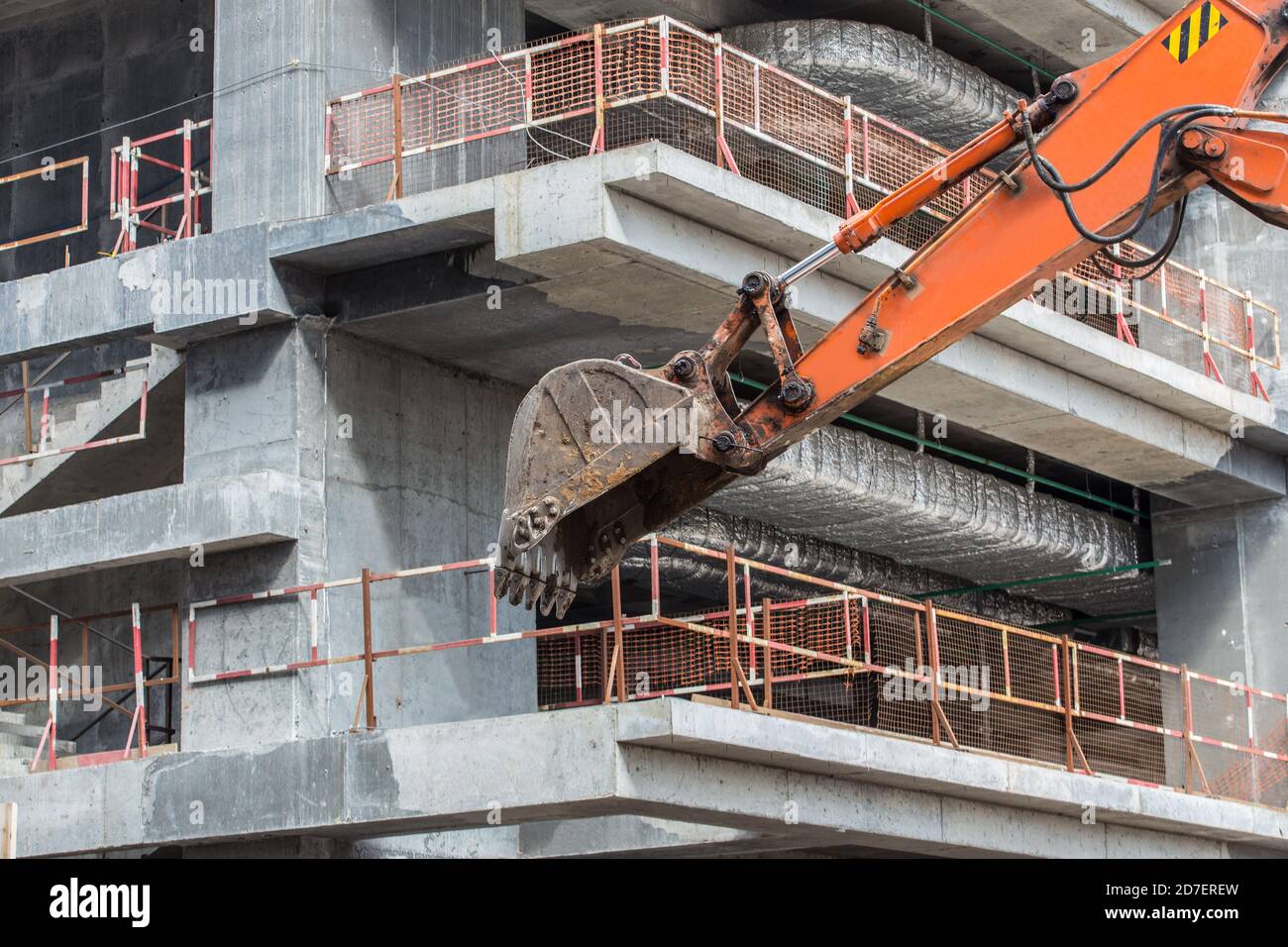 excavator on the construction of a modern concrete building Stock Photo ...