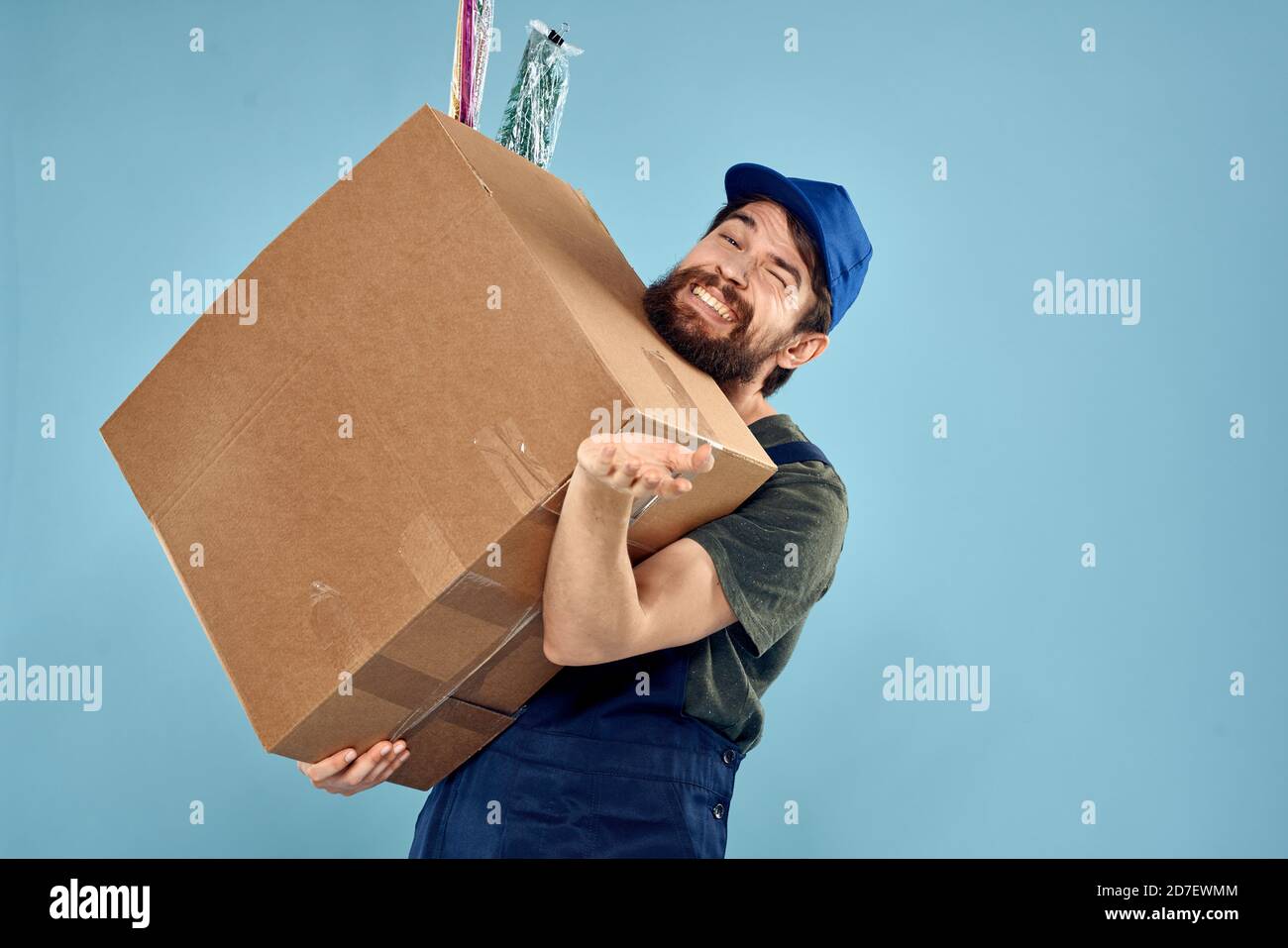 A man in working uniform with boxes in the hands of a carriage delivery ...
