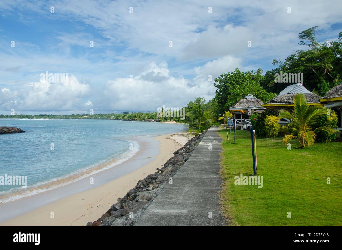 Sea surrounded by greenery and cottages under a cloudy sky in Manase ...