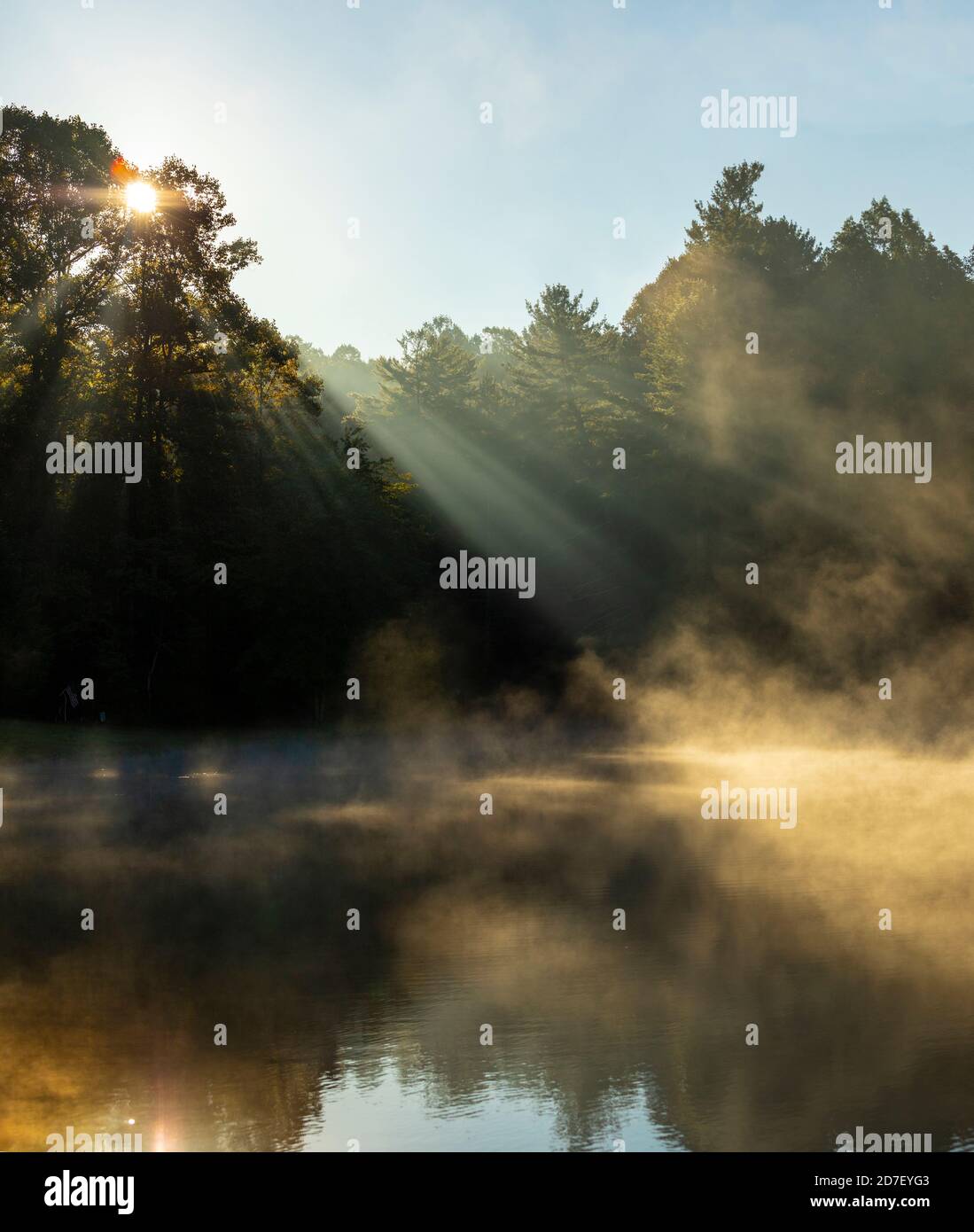 Sun rays coming through the trees onto water in the Blue Ridge ...