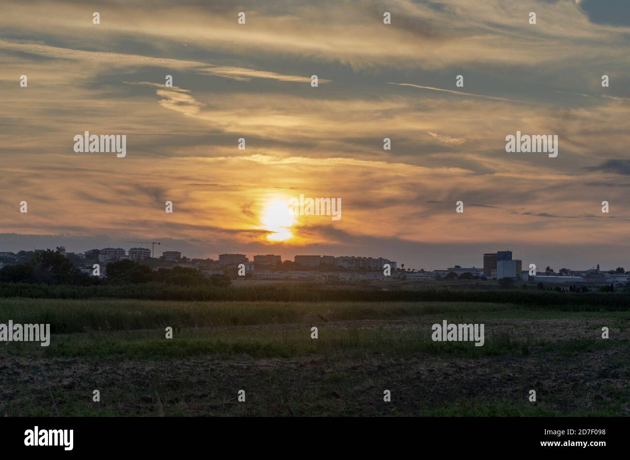 Urban panorama with sun at sunset Stock Photo - Alamy