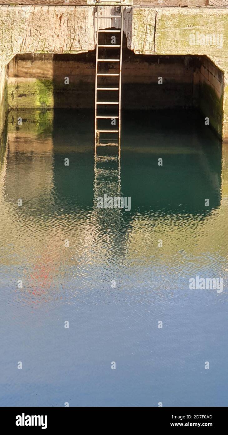 Harbour wall, ladder and reflections Stock Photo - Alamy