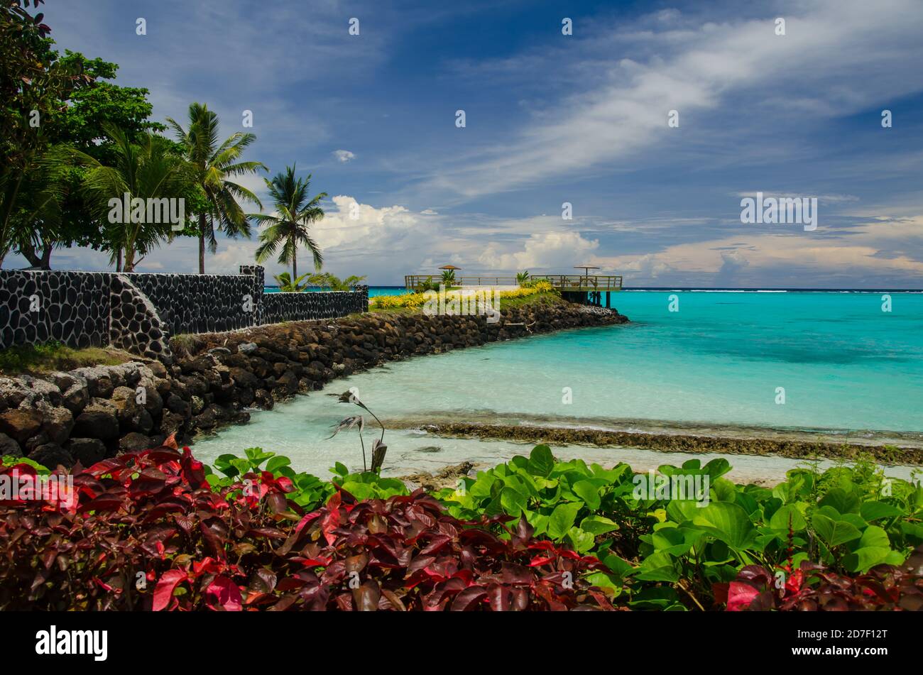Stone pier surrounded by greenery and sea under the sunlight in the ...