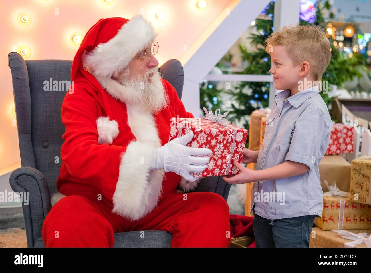 Santa Claus gives boy a gift in Shopping Mall. Real authentic Santa ...