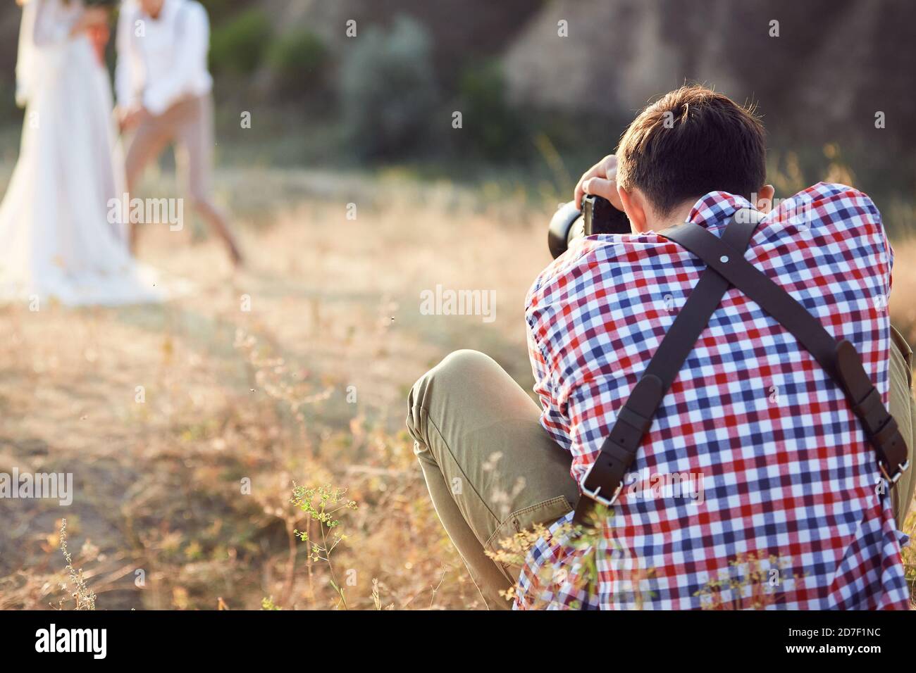 wedding professional photographer takes pictures of the bride and groom ...