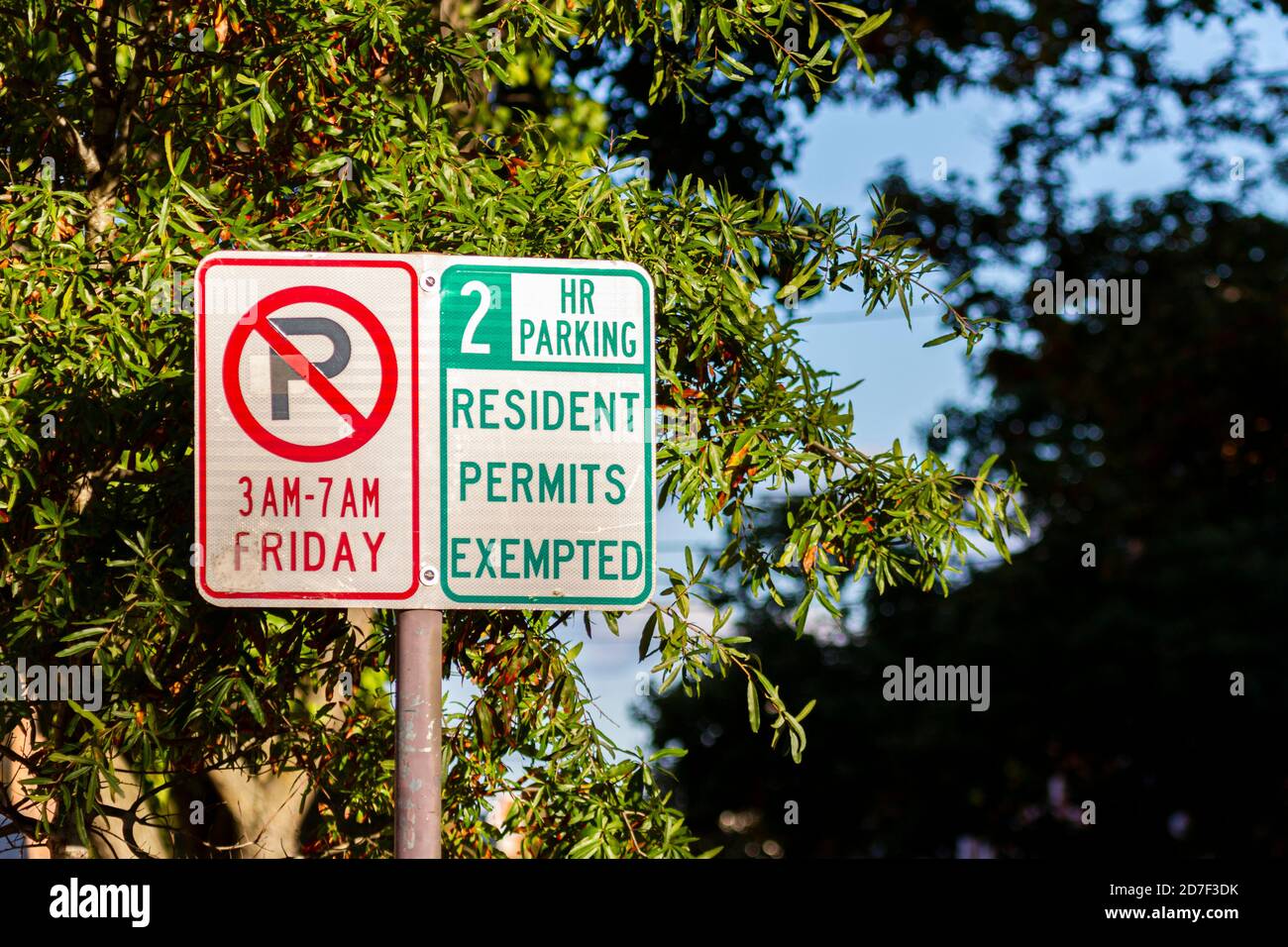 Side by side traffic signs one showing no parking on friday and the ...