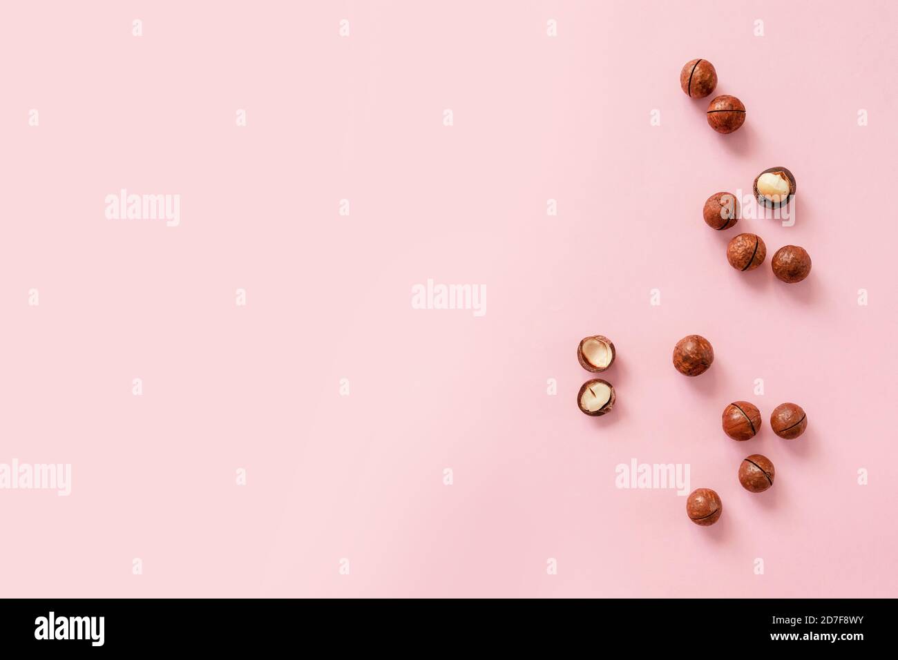Cracked macadamia nuts on pink background with copy space Stock Photo ...