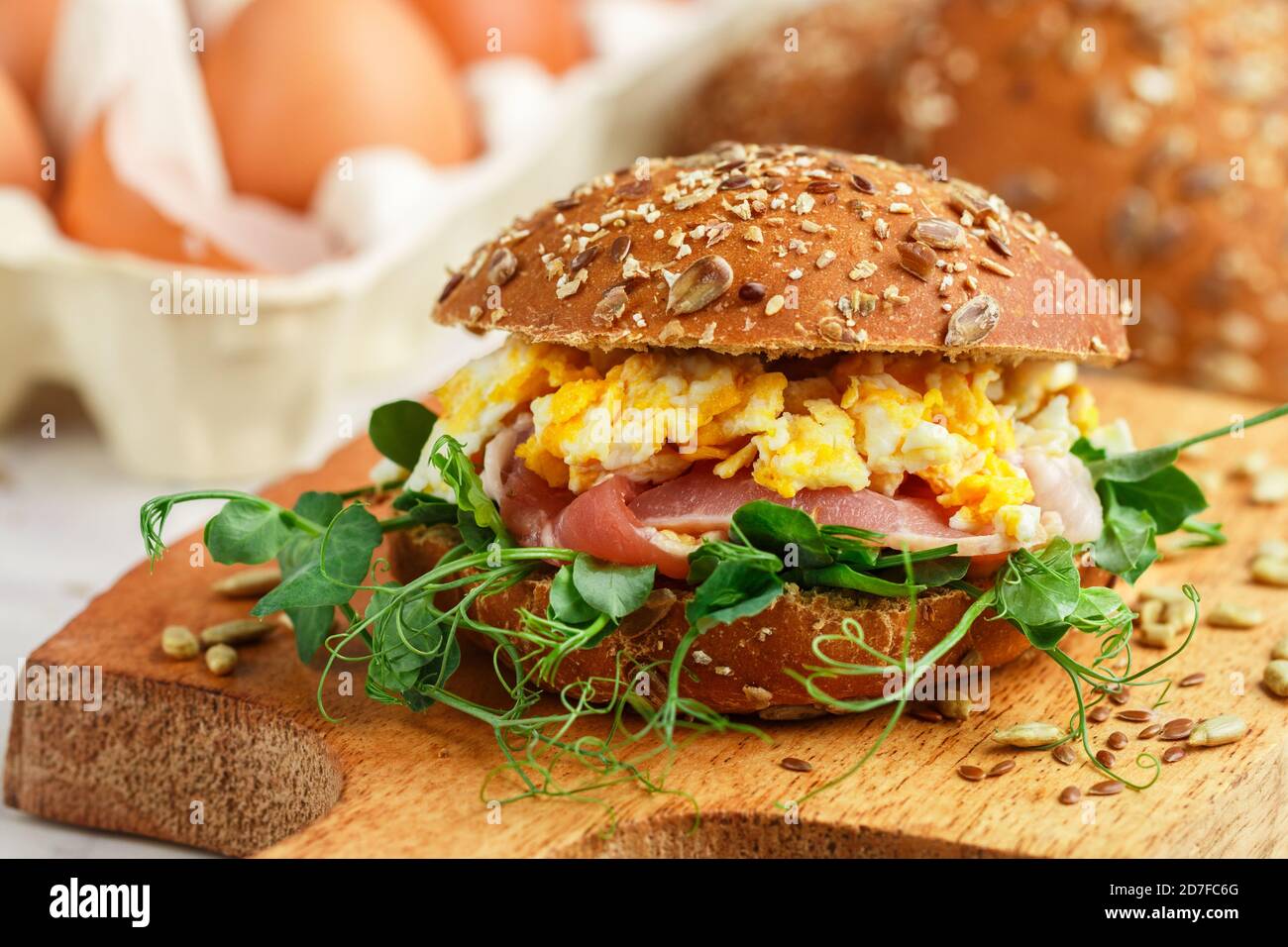 Wholegrain bun with sunflower and flax seeds with bacon, pea sprouts ...