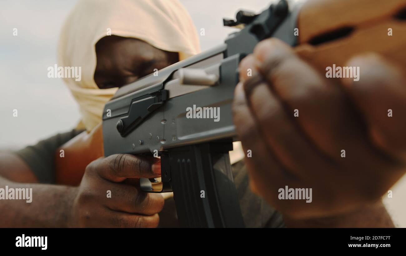 Concept of terrorism. Rebel soldier aiming at targets with an AK-47 ...