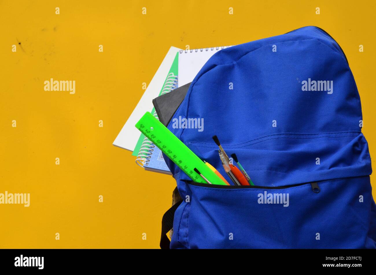 Full School backpack on yellow background. school supplies ruler ...