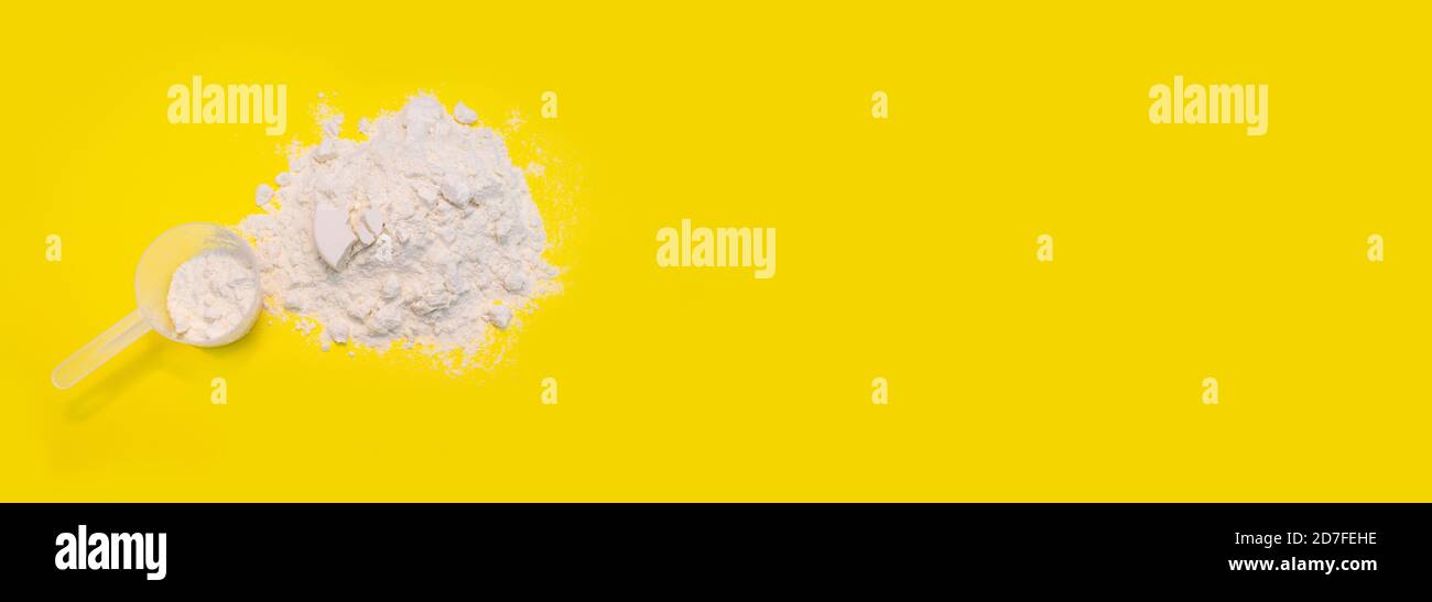 Banner pile of banana protein powder and measuring cup isolated on ...