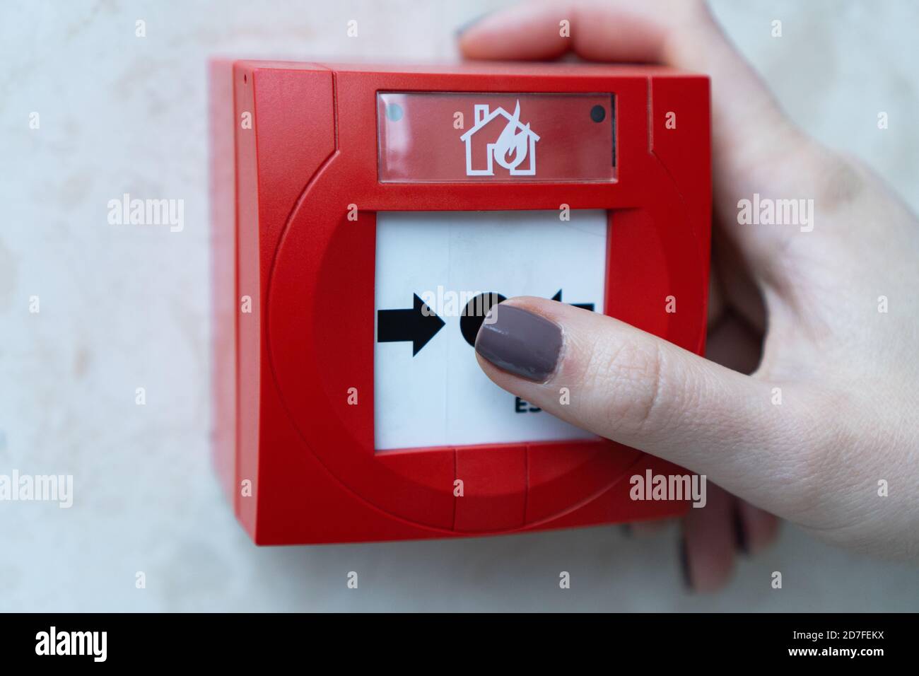 Human hands are pulling red fire alarms on the white walls along the ...