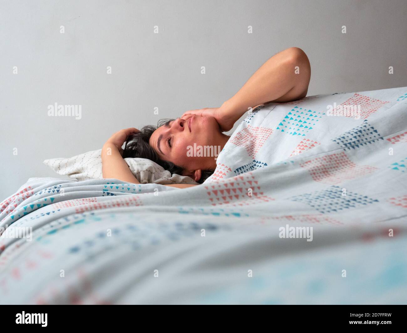 Young Brown Hair Hispanic Female Touches her Face Waking up in B Stock ...