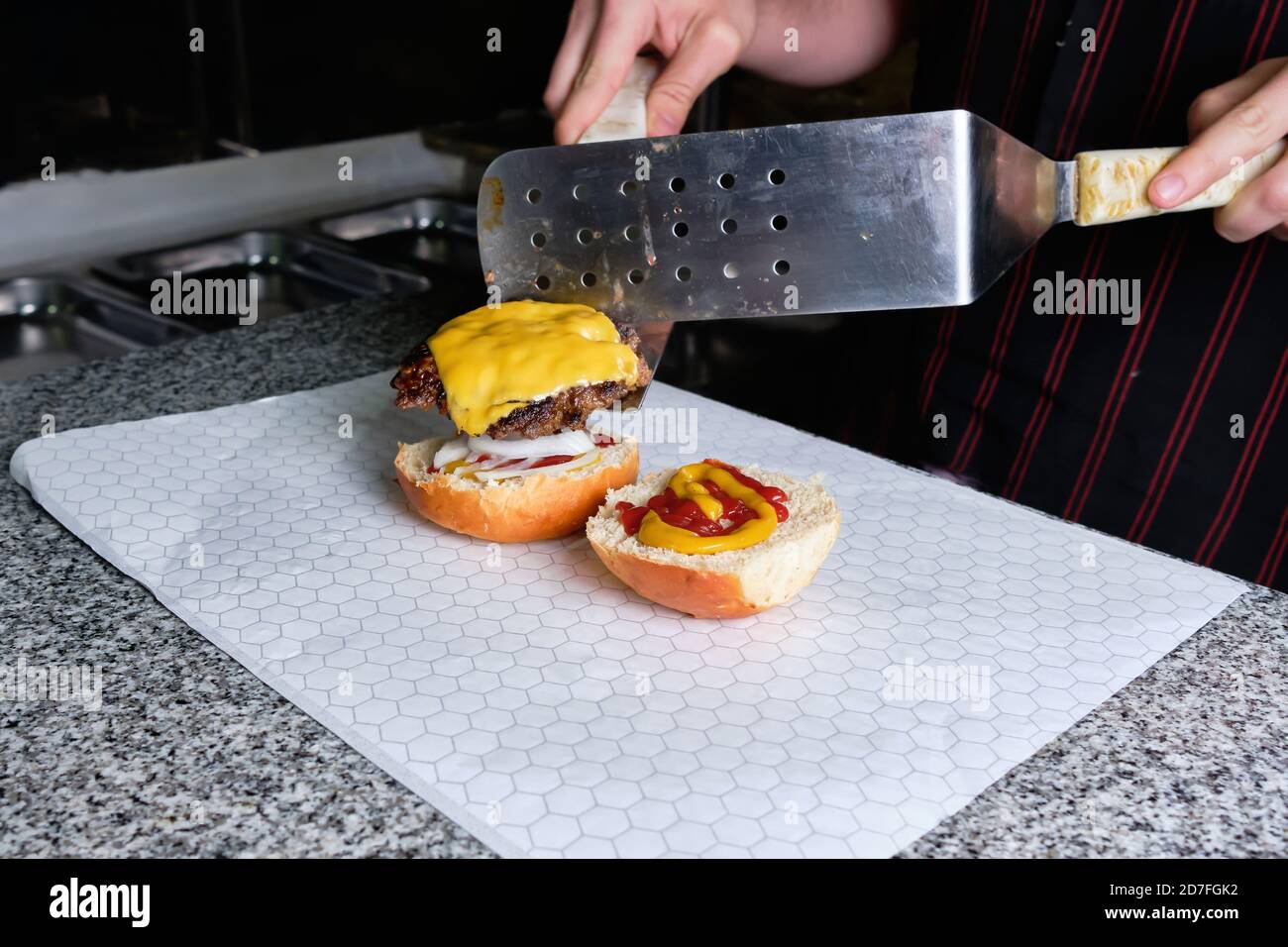 Man cooking american burger with cheddar, ketchup, hamburger in ...