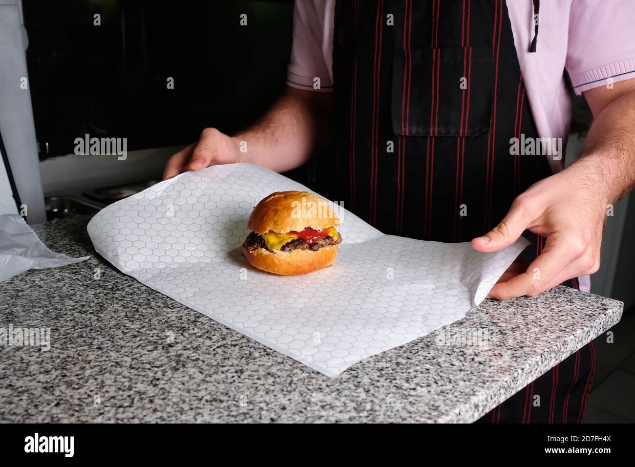 Man cooking american burger with cheddar, ketchup, hamburger in ...