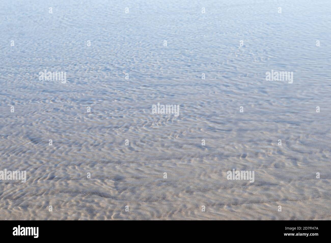 Textures made by water and wind on the sand at the beach, reflections ...