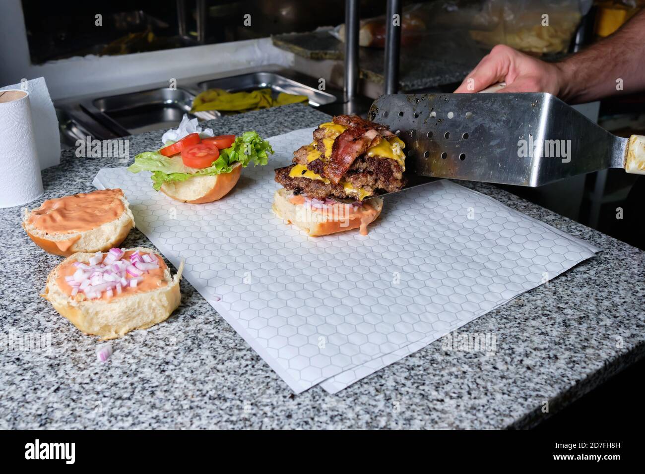 Man cooking american big burger with cheddar, ketchup, hamburger in ...