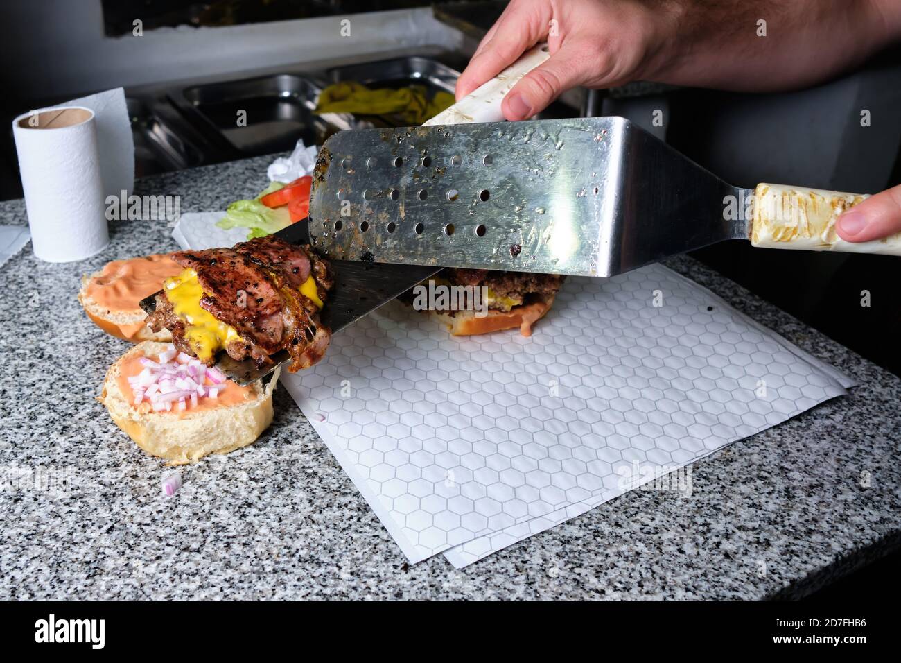 Man cooking american big burger with cheddar, ketchup, hamburger in ...