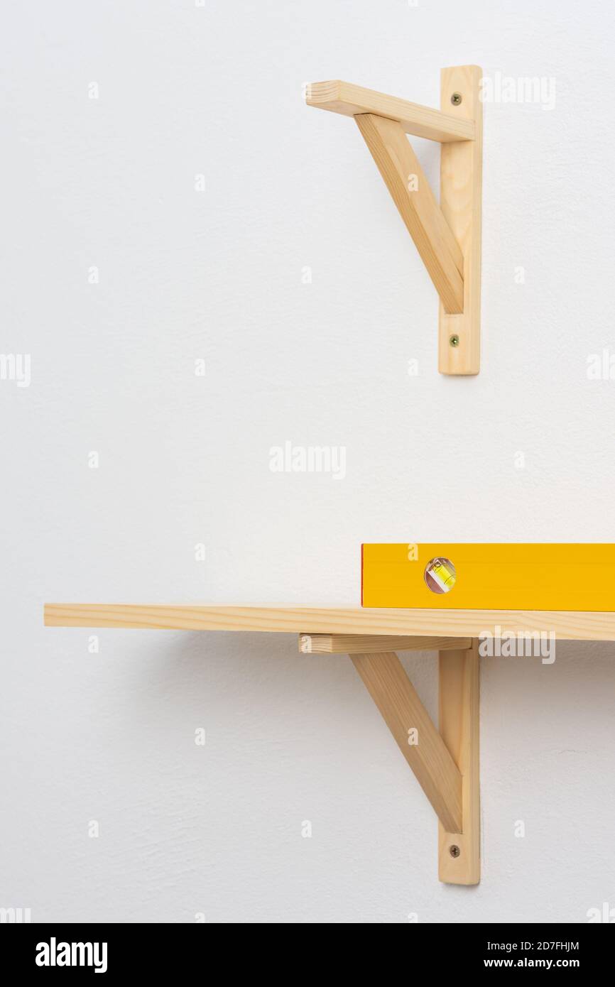 The process of fixing the wooden shelf to the wall, the level tool ...