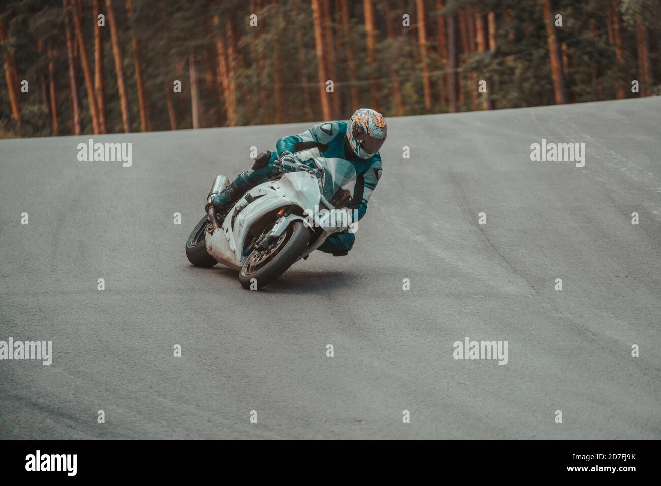 man riding motorcycle in asphalt road. Motorcyclist in blue suit at ...