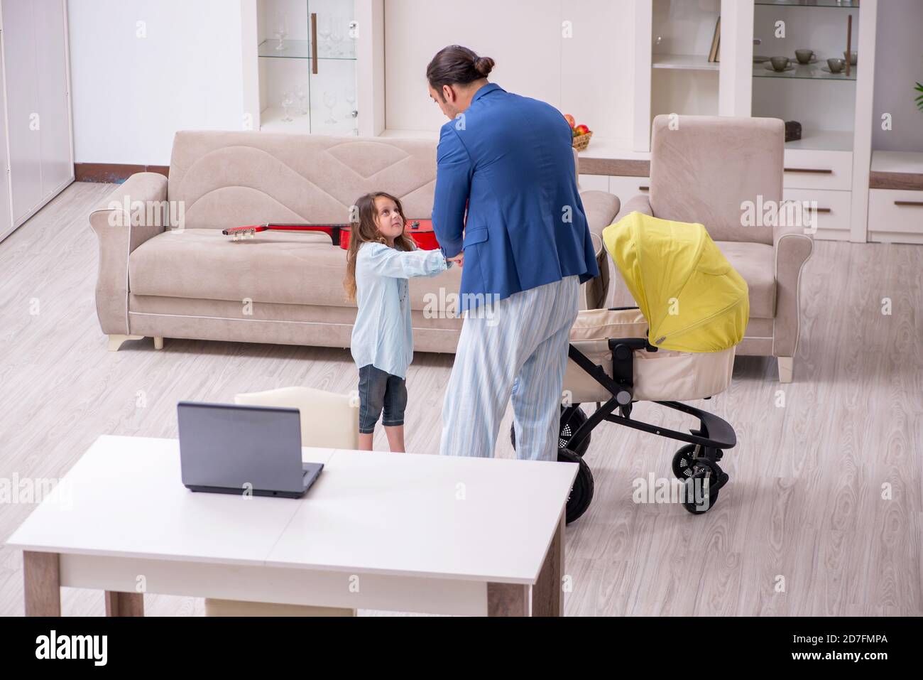 Young father of two children working from house Stock Photo - Alamy
