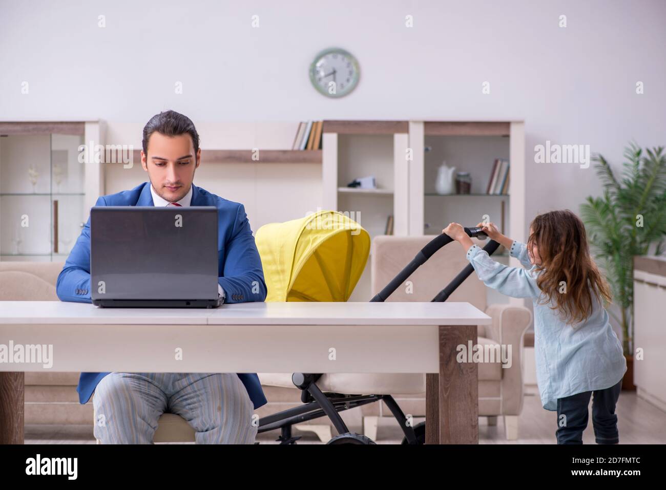 Young father of two children working from house Stock Photo - Alamy