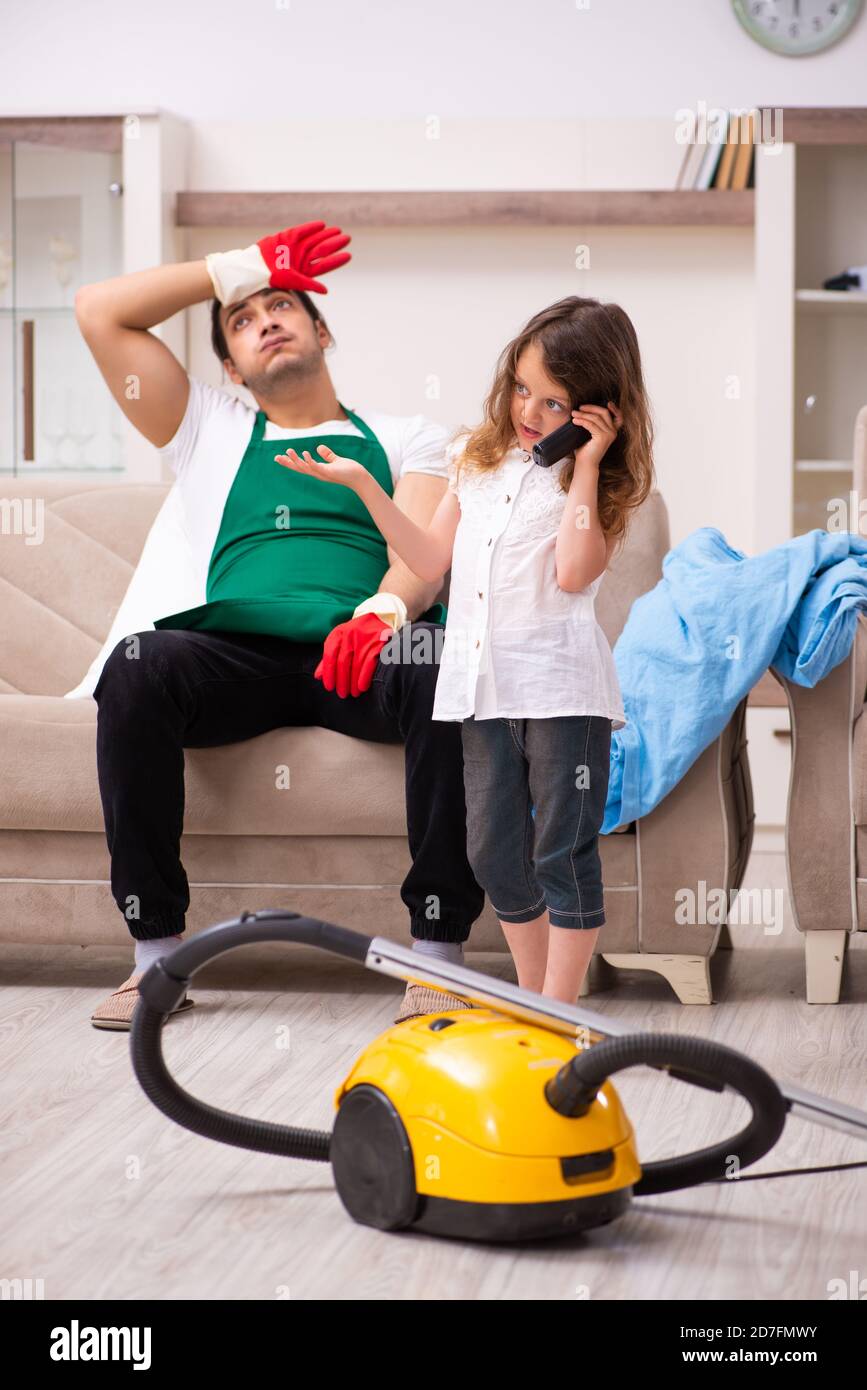 Young contractor cleaning the house with his small daughter Stock Photo ...