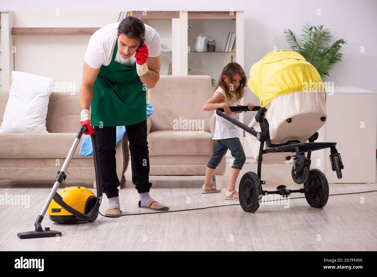 Young contractor cleaning the house with his small daughter Stock Photo ...