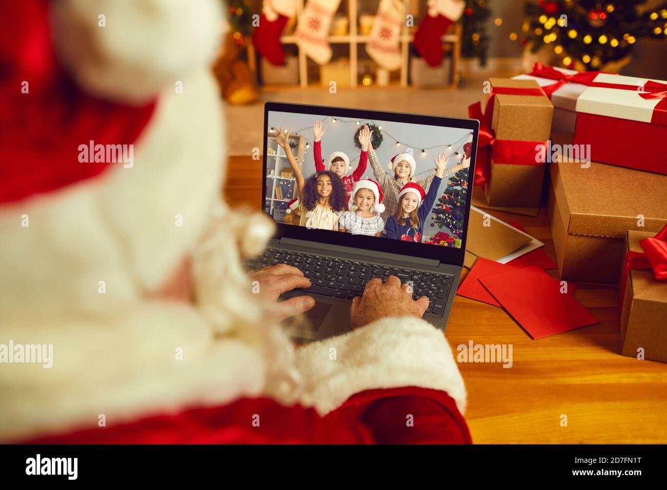 Santa Claus having video call with happy kids on laptop computer in his ...