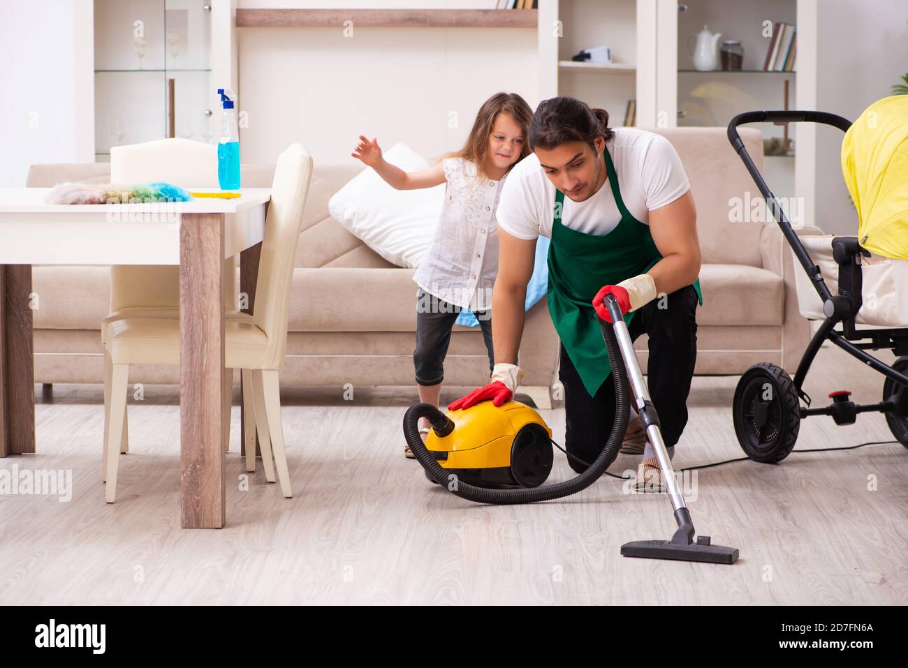 Young contractor cleaning the house with his small daughter Stock Photo ...