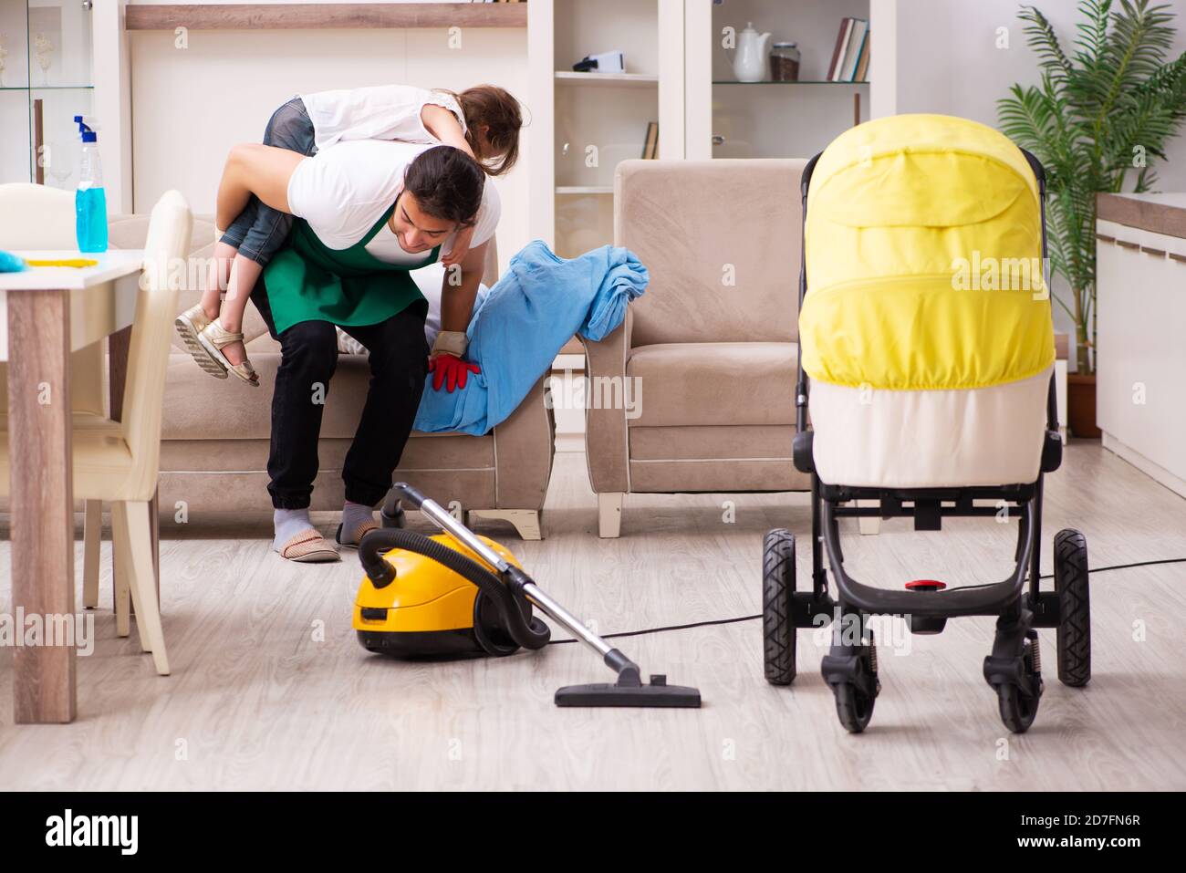 Young contractor cleaning the house with his small daughter Stock Photo ...