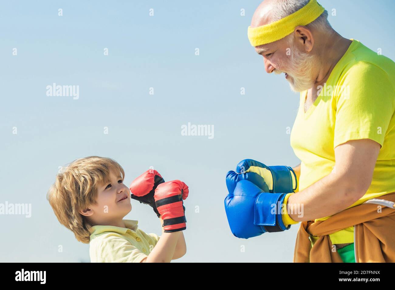 Grandpa and little child boy in boxing stance doing exercises with ...