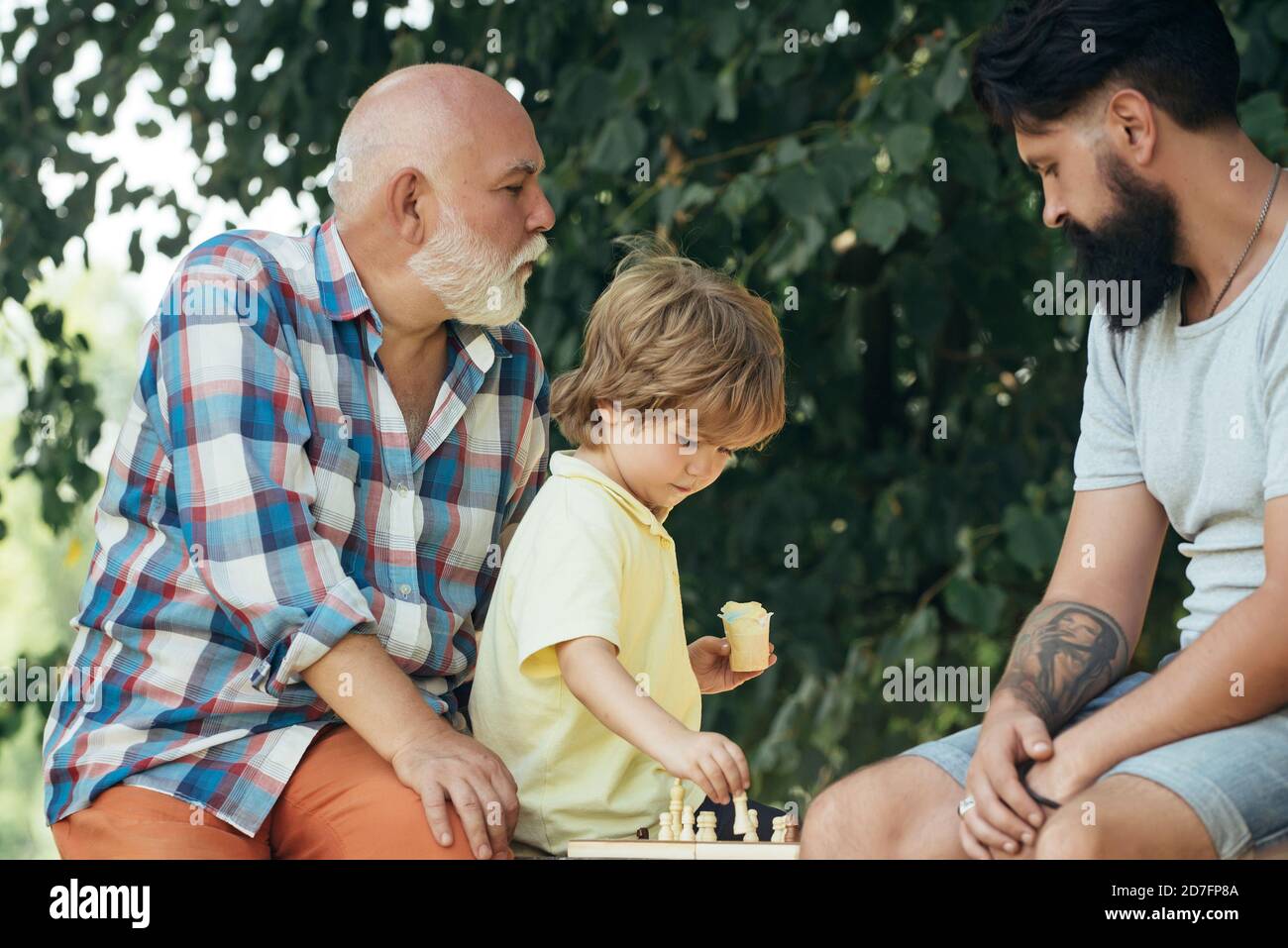 Handsome grandpa and grandson are playing chess while spending time ...