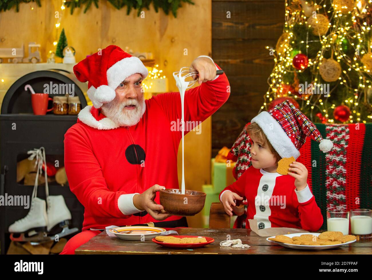 Santa helper. Cute little child boy and daddy make gingerbread cookies ...
