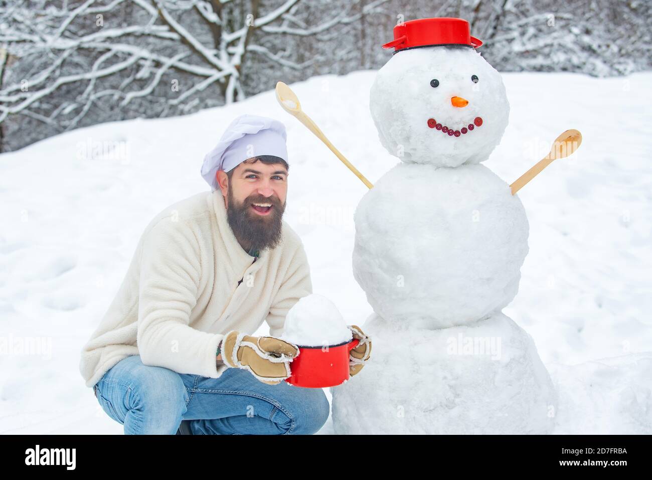 Funny Christmas cook. Happy father chef playing with a snowman on a ...
