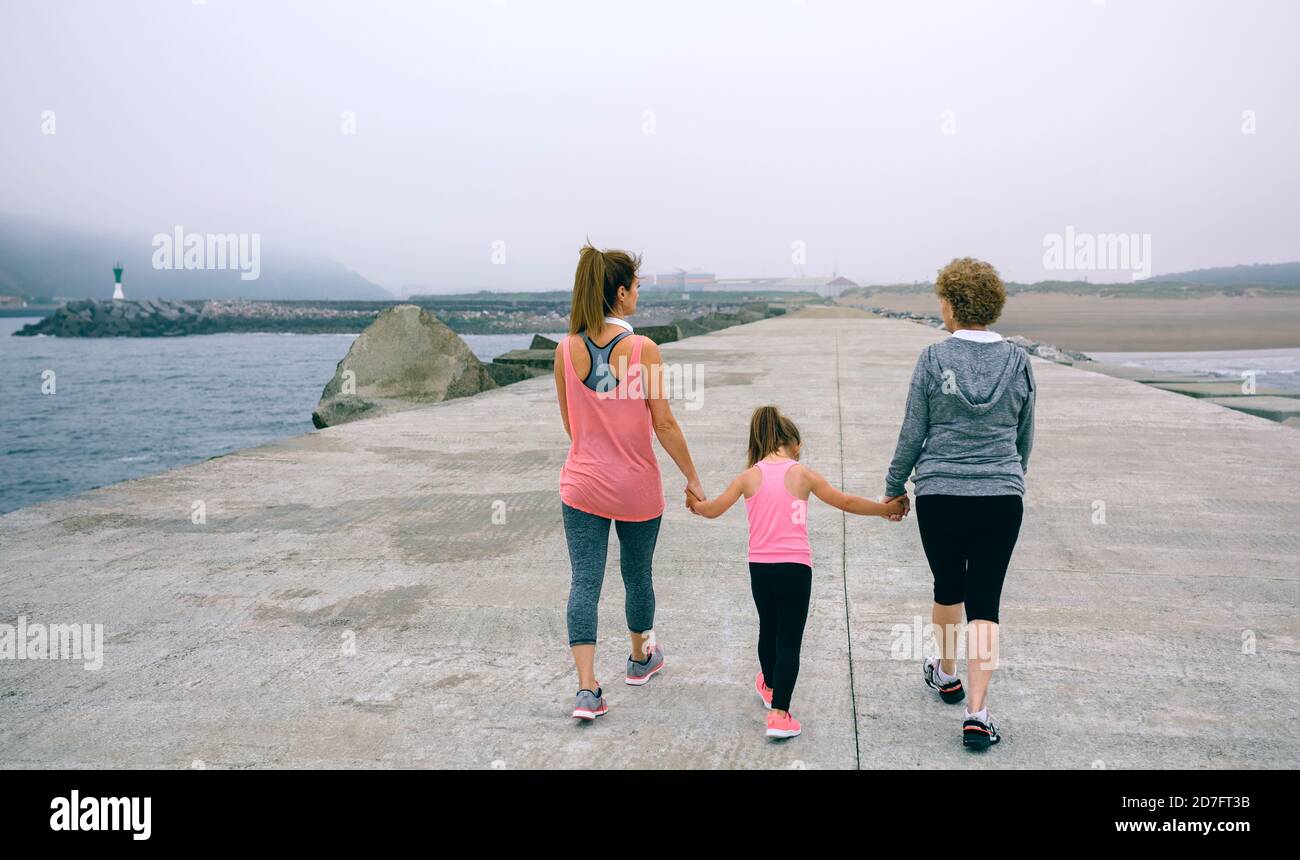 Back view of three female generations walking Stock Photo - Alamy