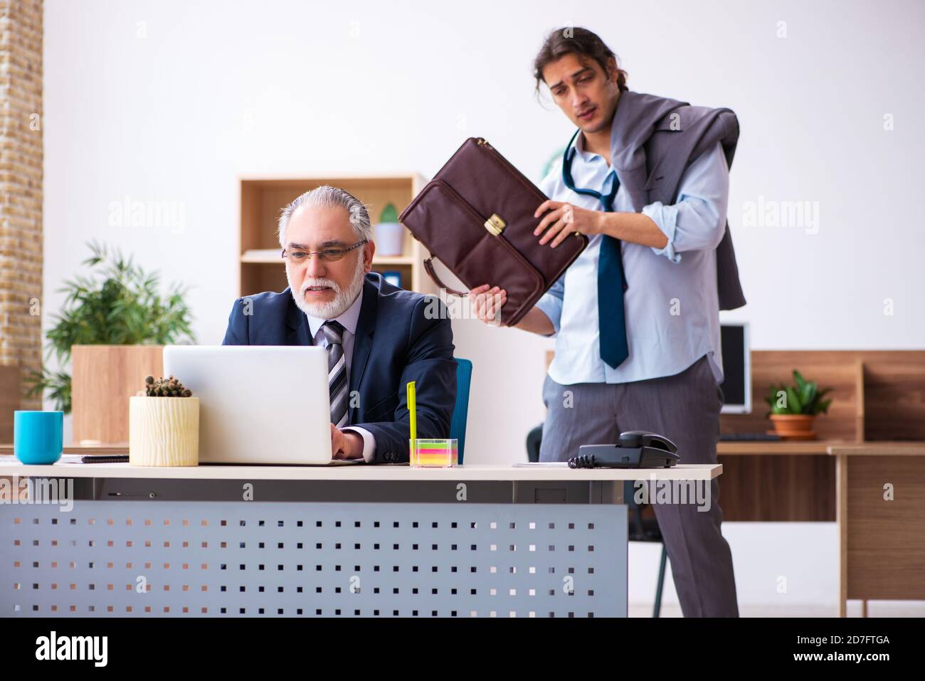 Old boss and young male employee in time management concept Stock Photo ...