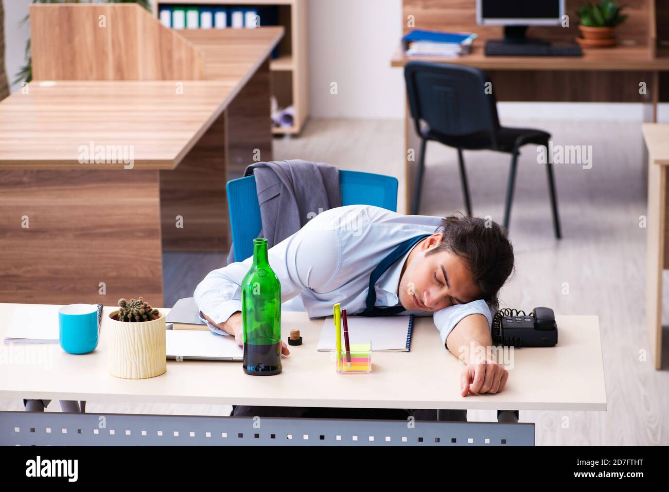 Male employee drinking alcohol at workplace Stock Photo - Alamy