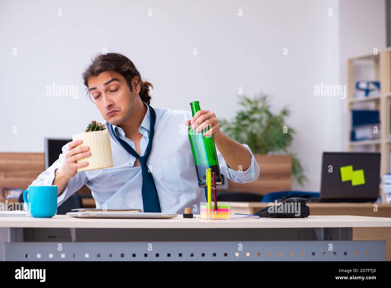 Male employee drinking alcohol at workplace Stock Photo - Alamy